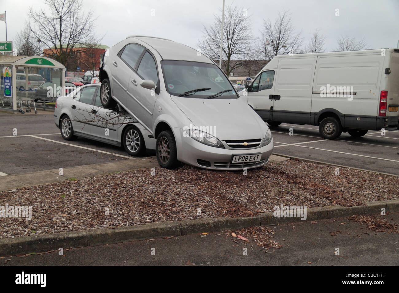 A car park incident where one car was accidentally reversed up a kerb ...