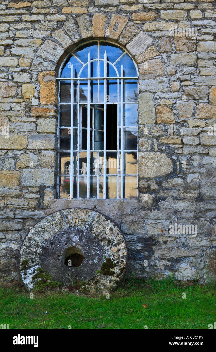 Glass window in stone building with mill stone Stock Photo - Alamy