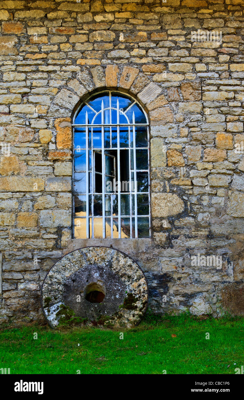 Glass window in stone building with mill stone Stock Photo - Alamy