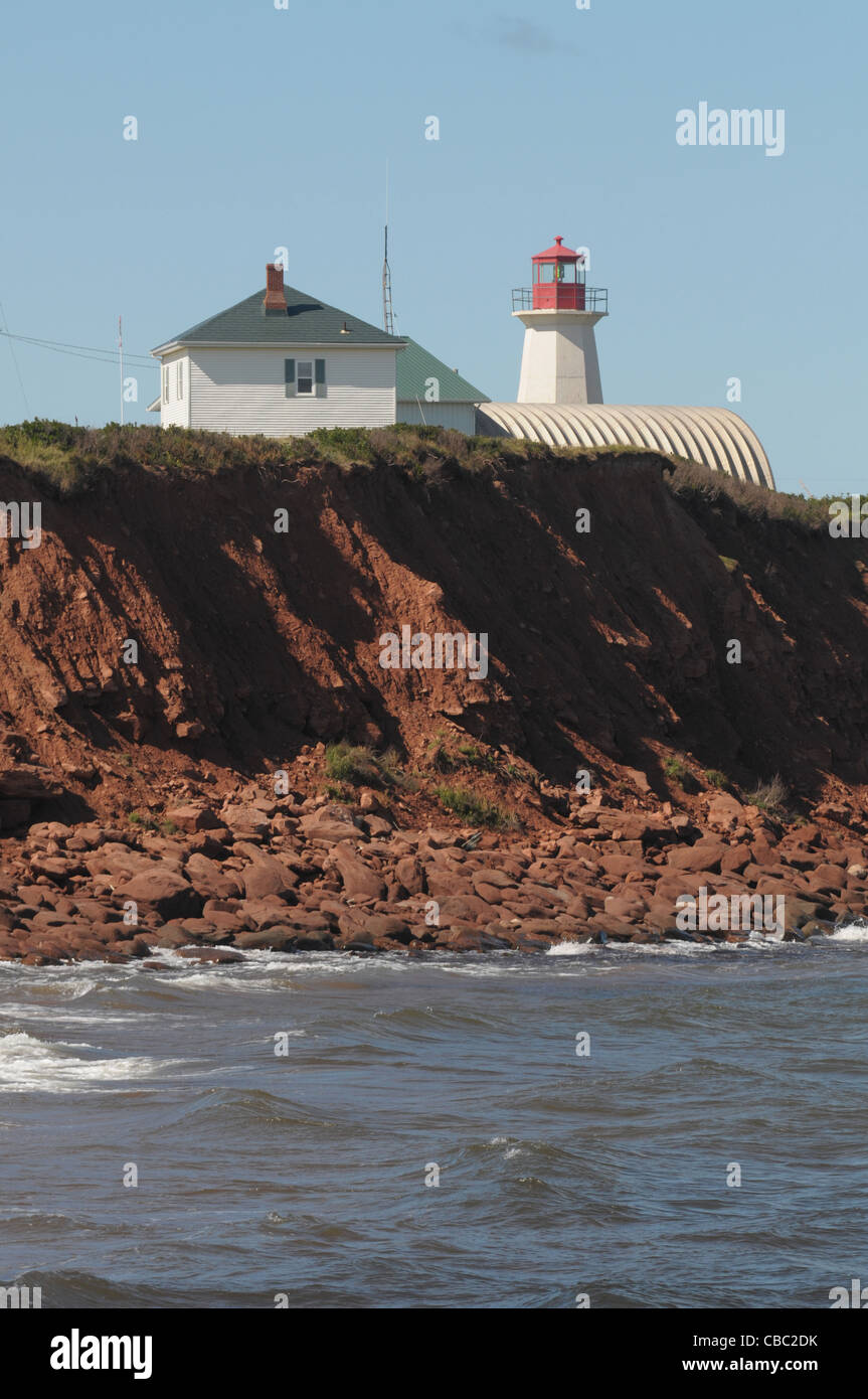 A lighthouse sits atop the red cliffs of North Lake Harbor , Prince ...