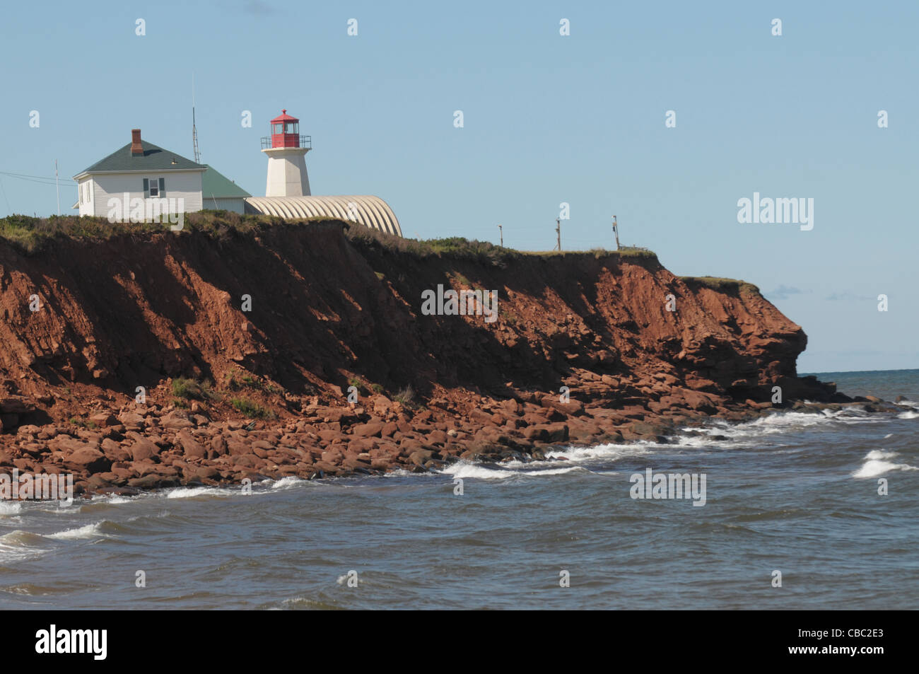 A lighthouse sits atop the red cliffs of North Lake Harbor , Prince ...