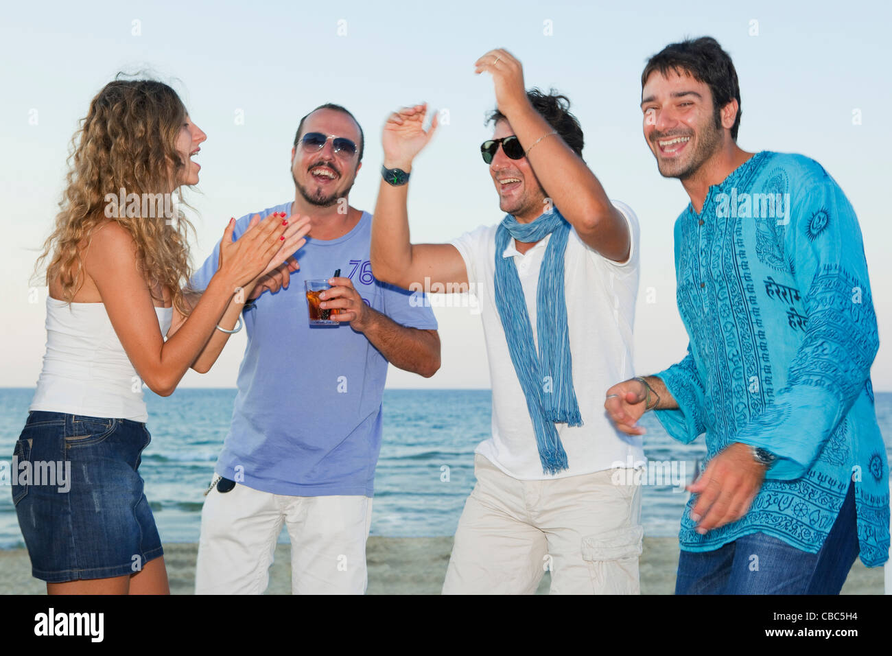 Friends laughing together on beach Stock Photo - Alamy