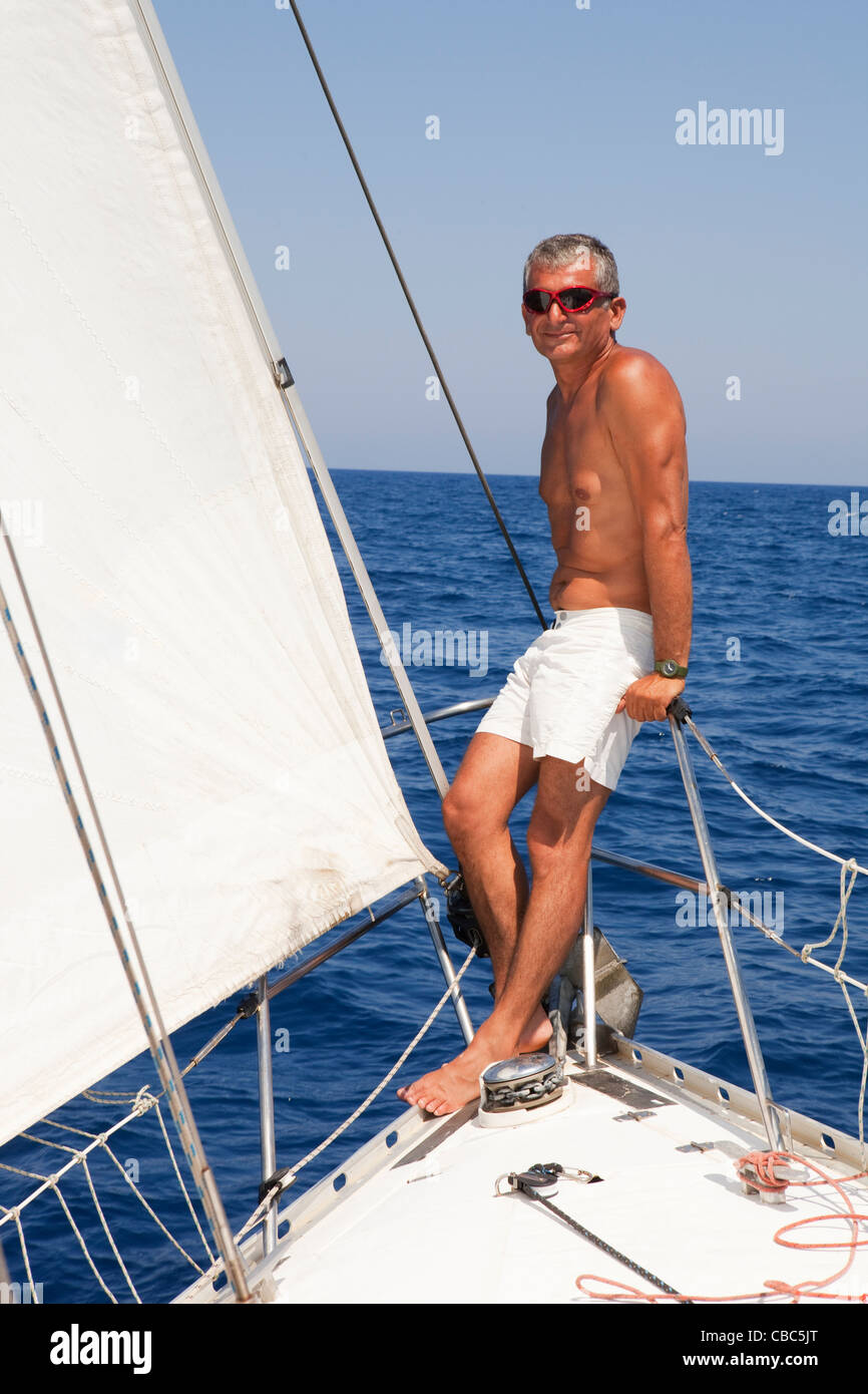 Older man on railing of sailboat Stock Photo - Alamy