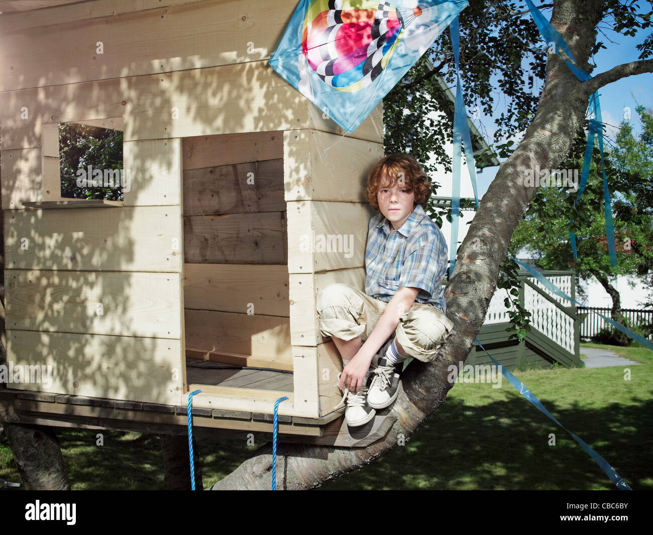 Boy playing in treehouse Stock Photo - Alamy