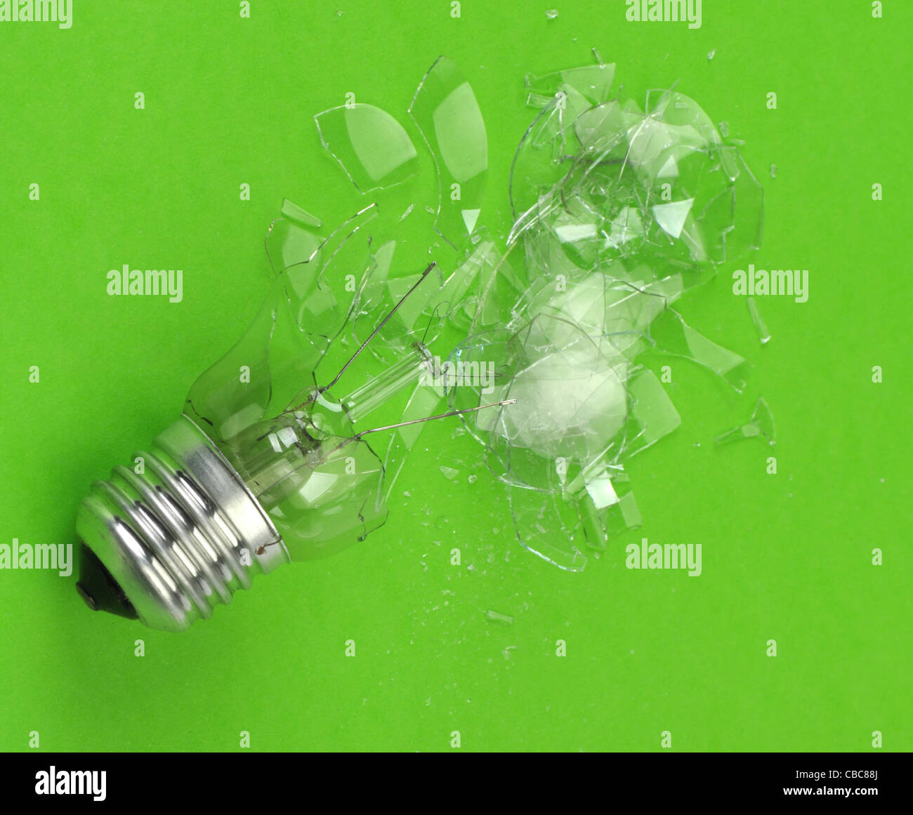 The broken bulb. Glass splinters on a green background Stock Photo - Alamy