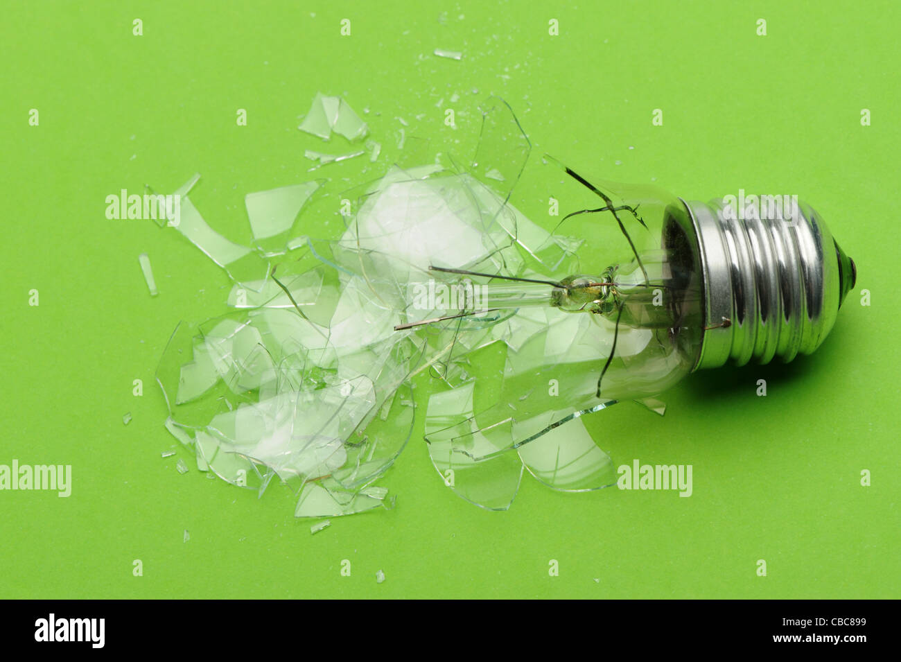 The broken bulb. Glass splinters on a green background Stock Photo - Alamy