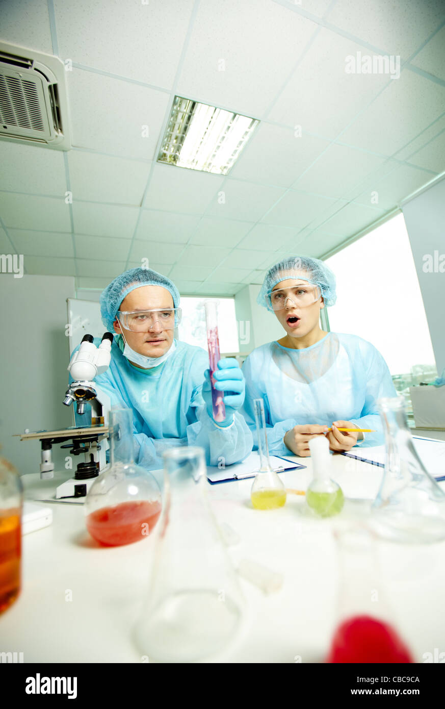 Surprised chemists making experiment with new substance in laboratory ...