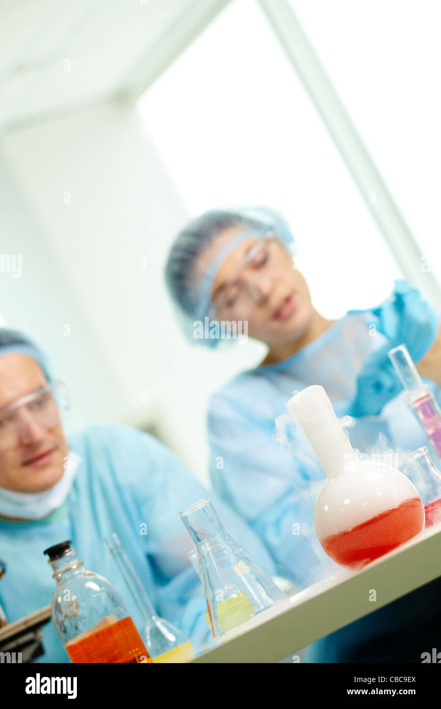 Laboratory bottle with chemical substance during experiment with two ...
