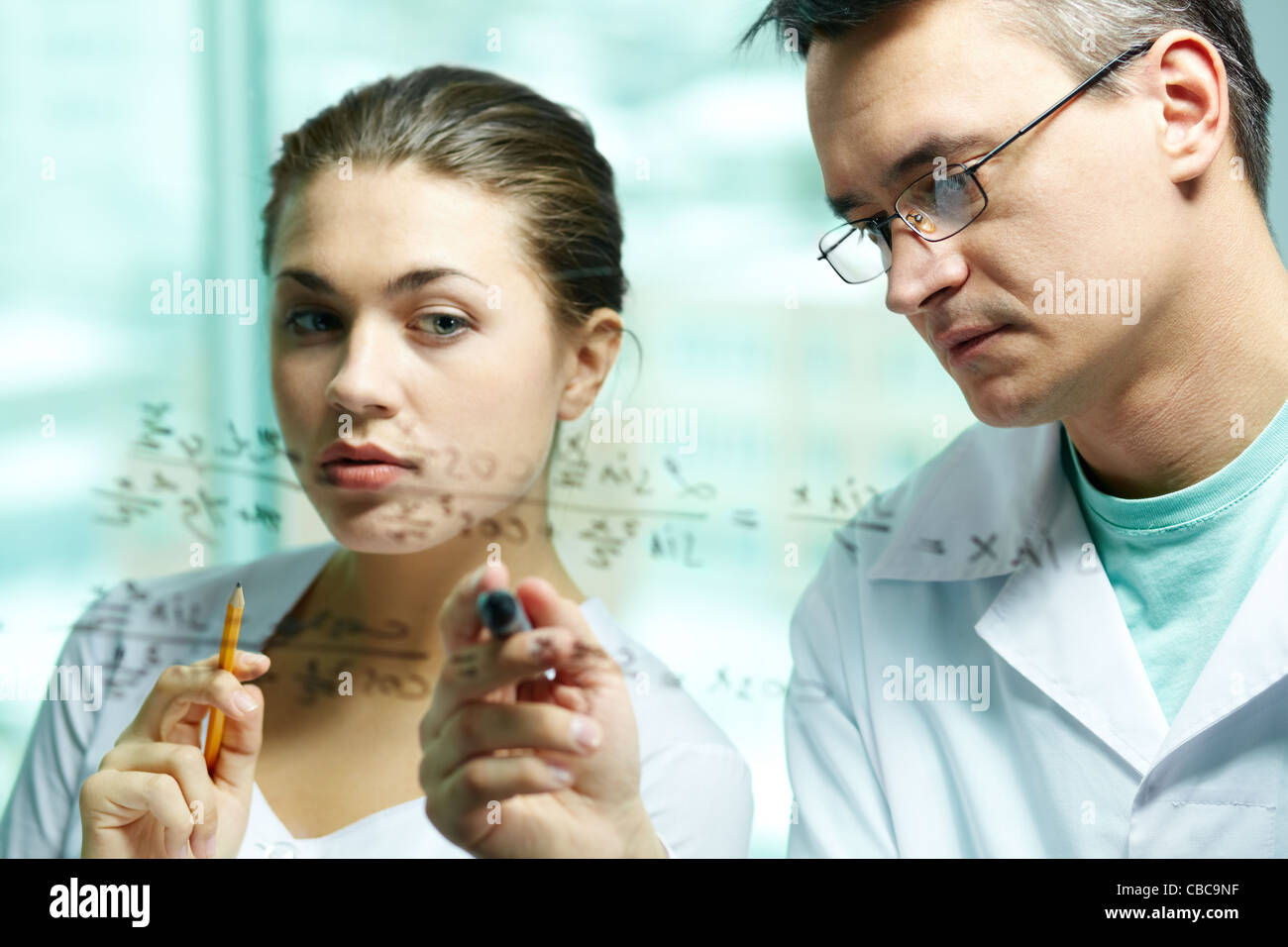 Serious scientist explaining chemical formula to his co-worker Stock ...