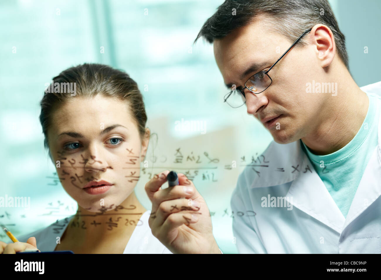 Serious scientist explaining chemical formula to his co-worker Stock ...