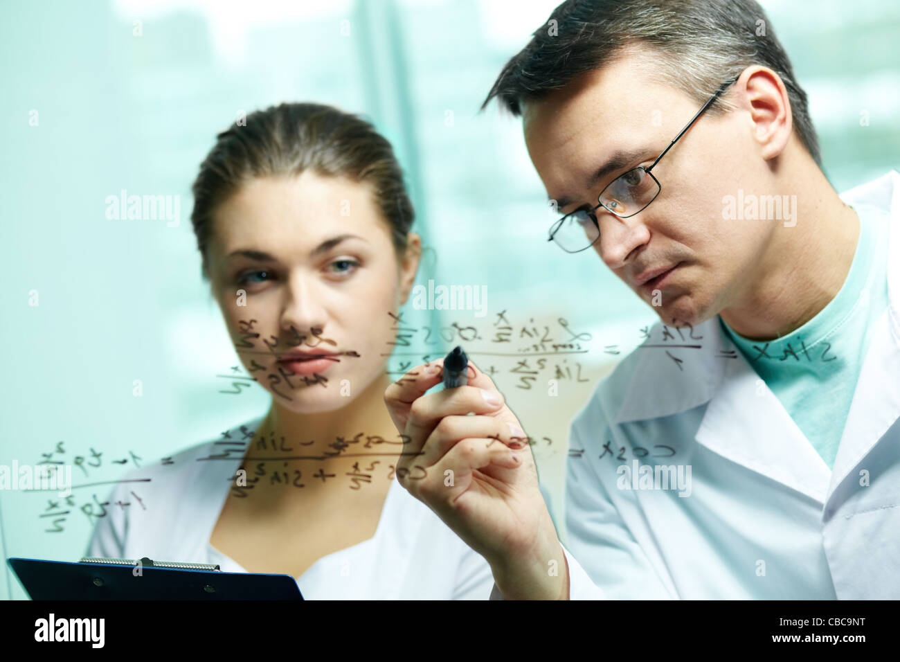 Serious scientist explaining chemical formula to his co-worker Stock ...