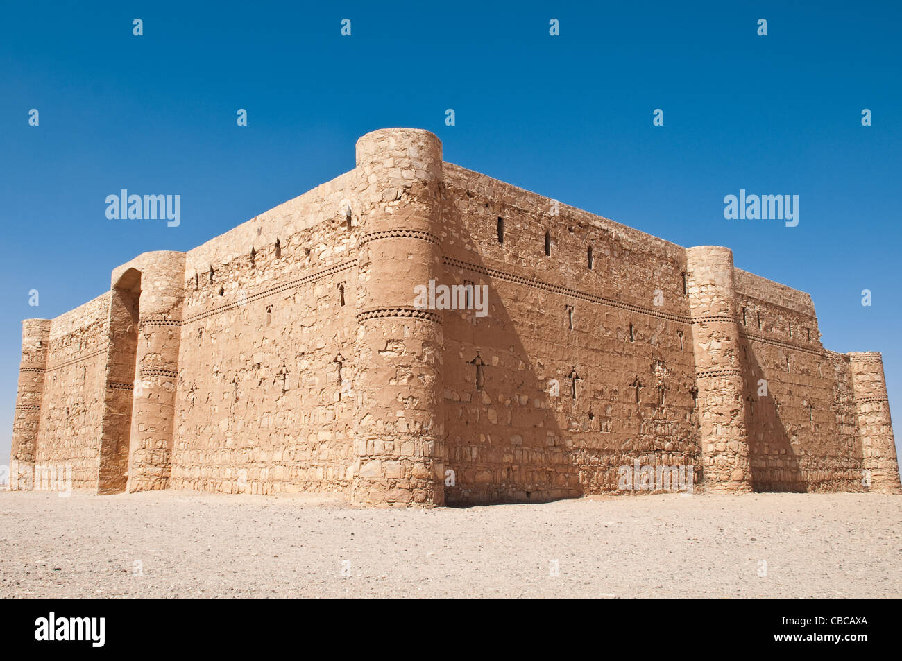 ancient desert castle with blue sky in background in Jordan Stock Photo ...