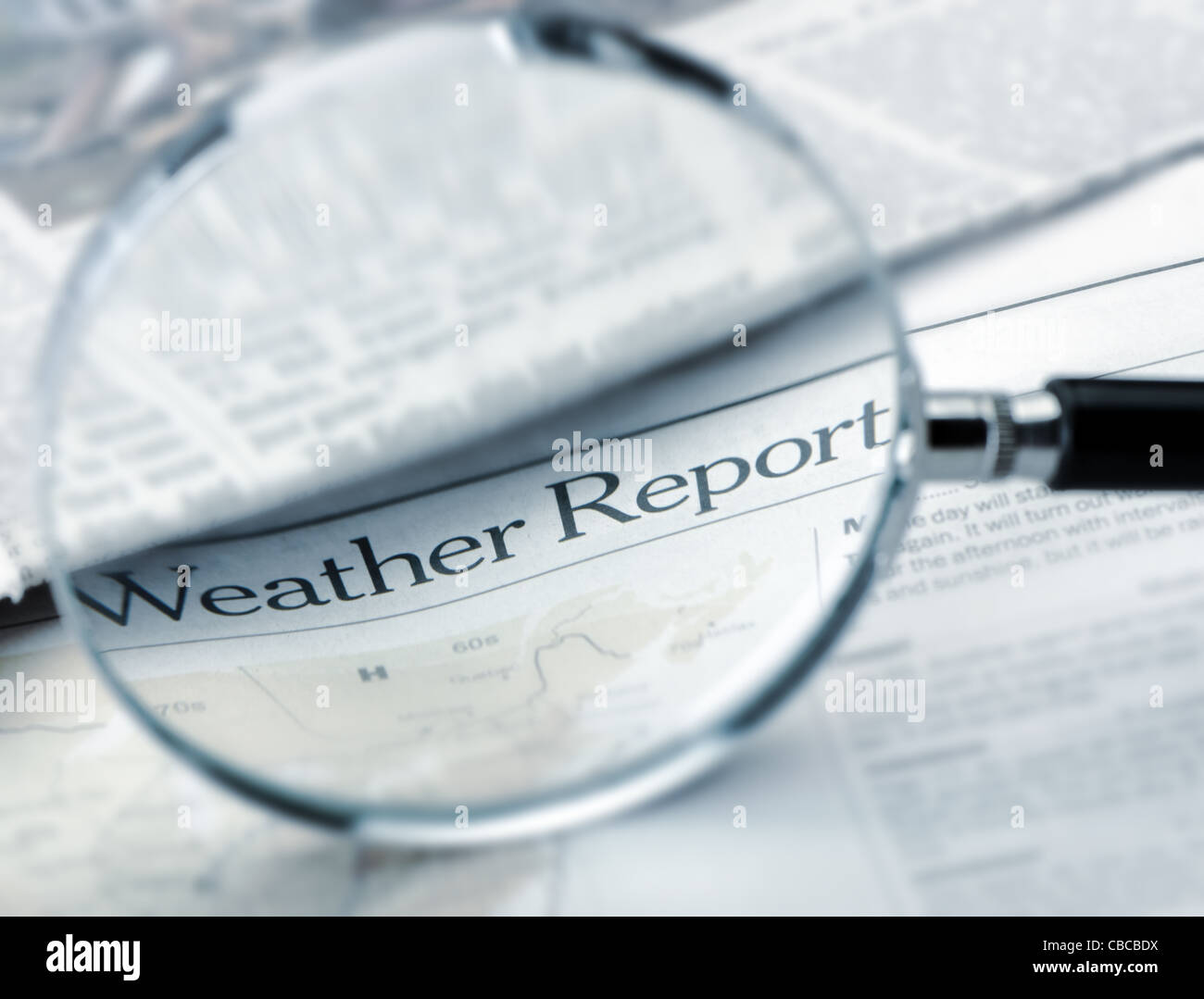 Loupe lies on the newspaper with title Weather report.Blue toned. A ...