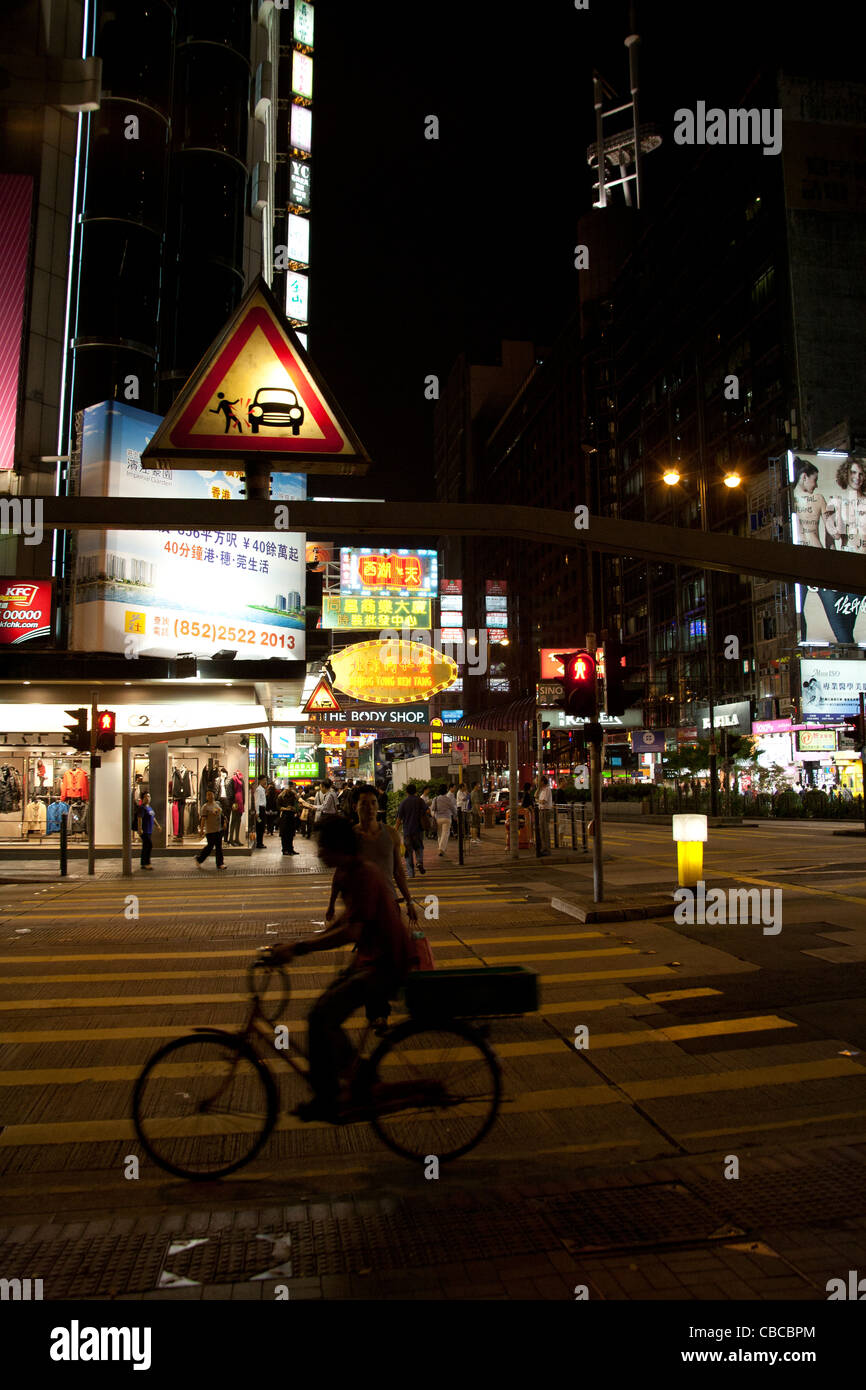 Cyclist cycling down busy road Nathan Road at night, the main ...