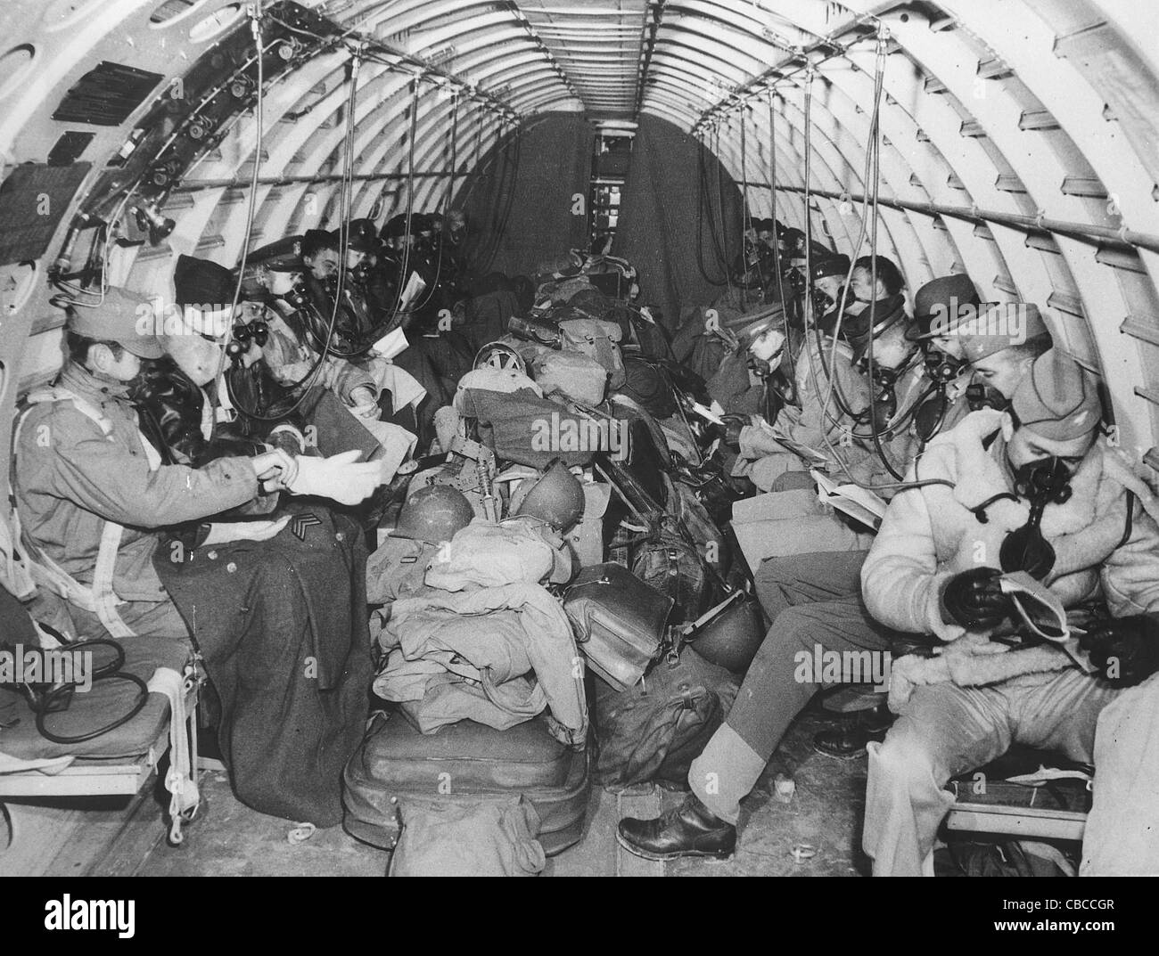 Passengers in a USAAF C46 Commando aircraft use oxygen while flying ...