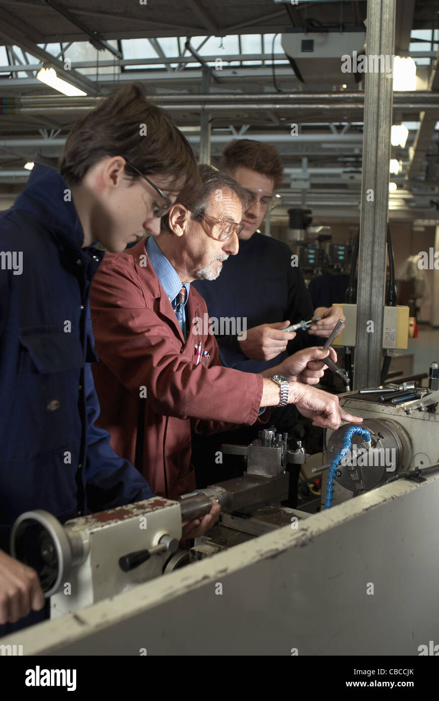 Teacher helping students in shop class Stock Photo - Alamy