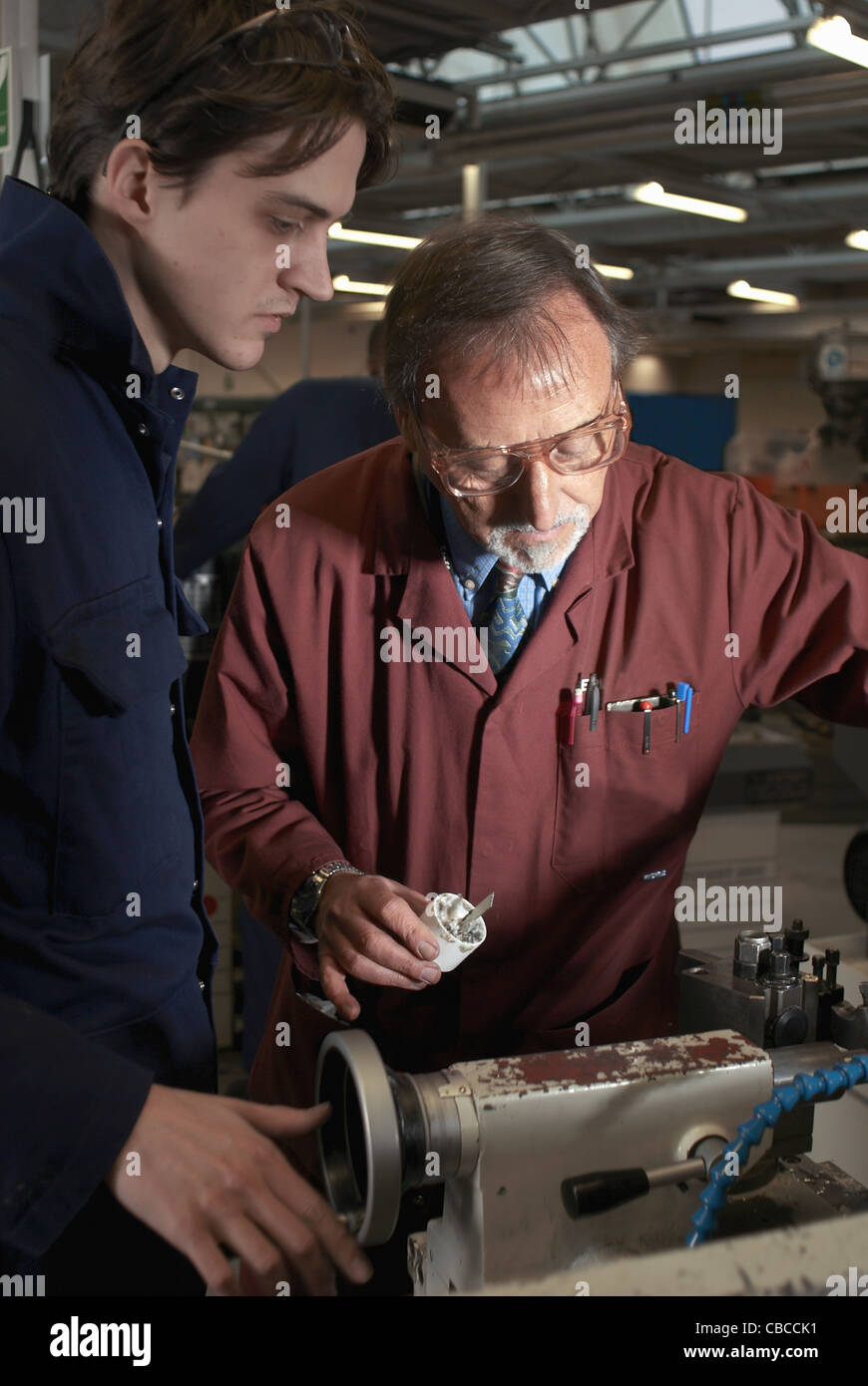 Teacher helping student in shop class Stock Photo - Alamy