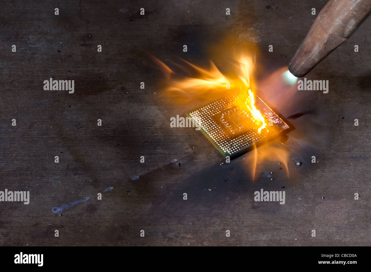 burning a central processing unit on metallic ground with welding torch ...