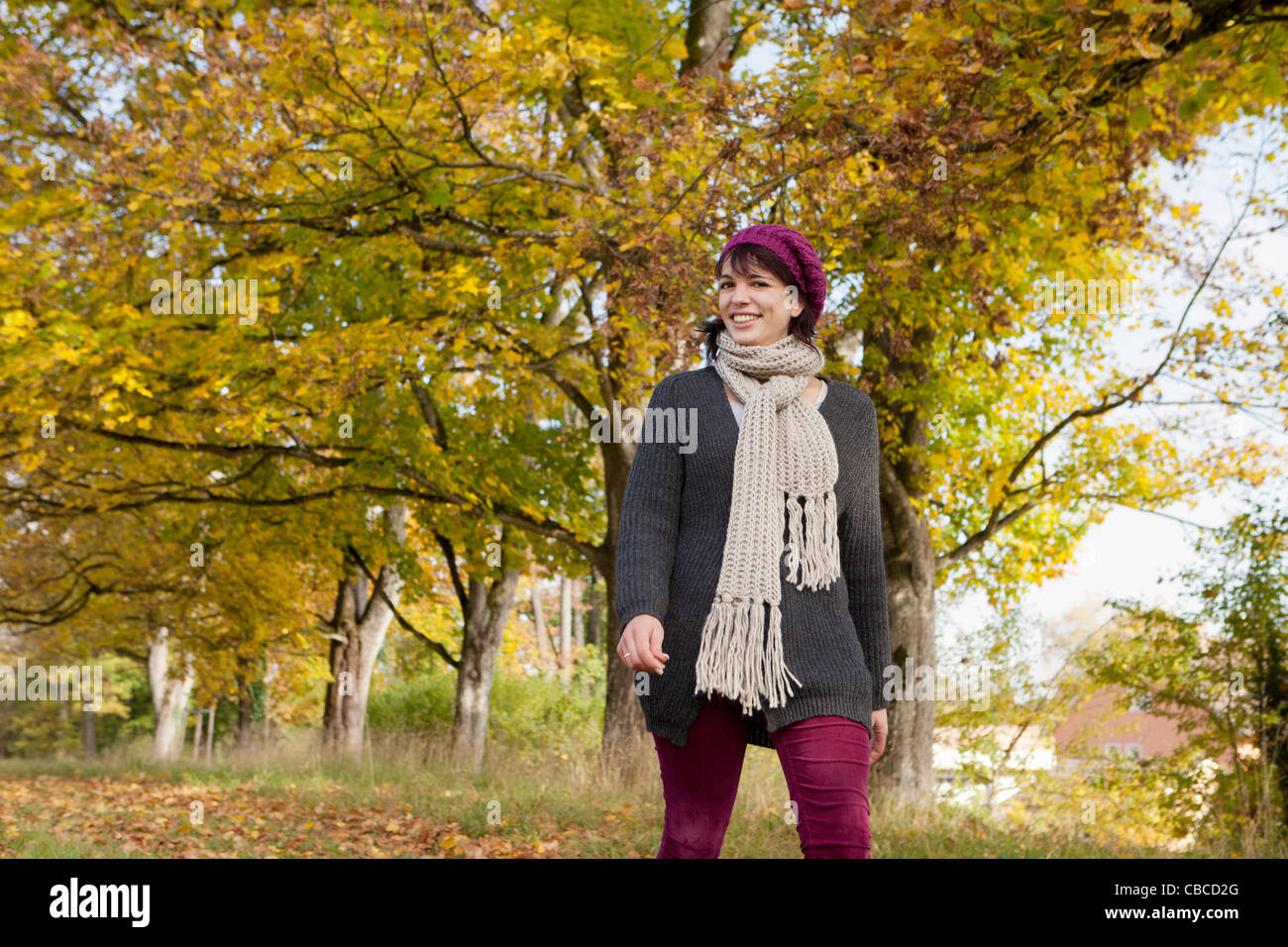 Smiling woman walking in park Stock Photo - Alamy