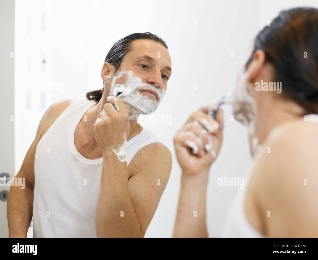 Man shaving his face in bathroom Stock Photo - Alamy