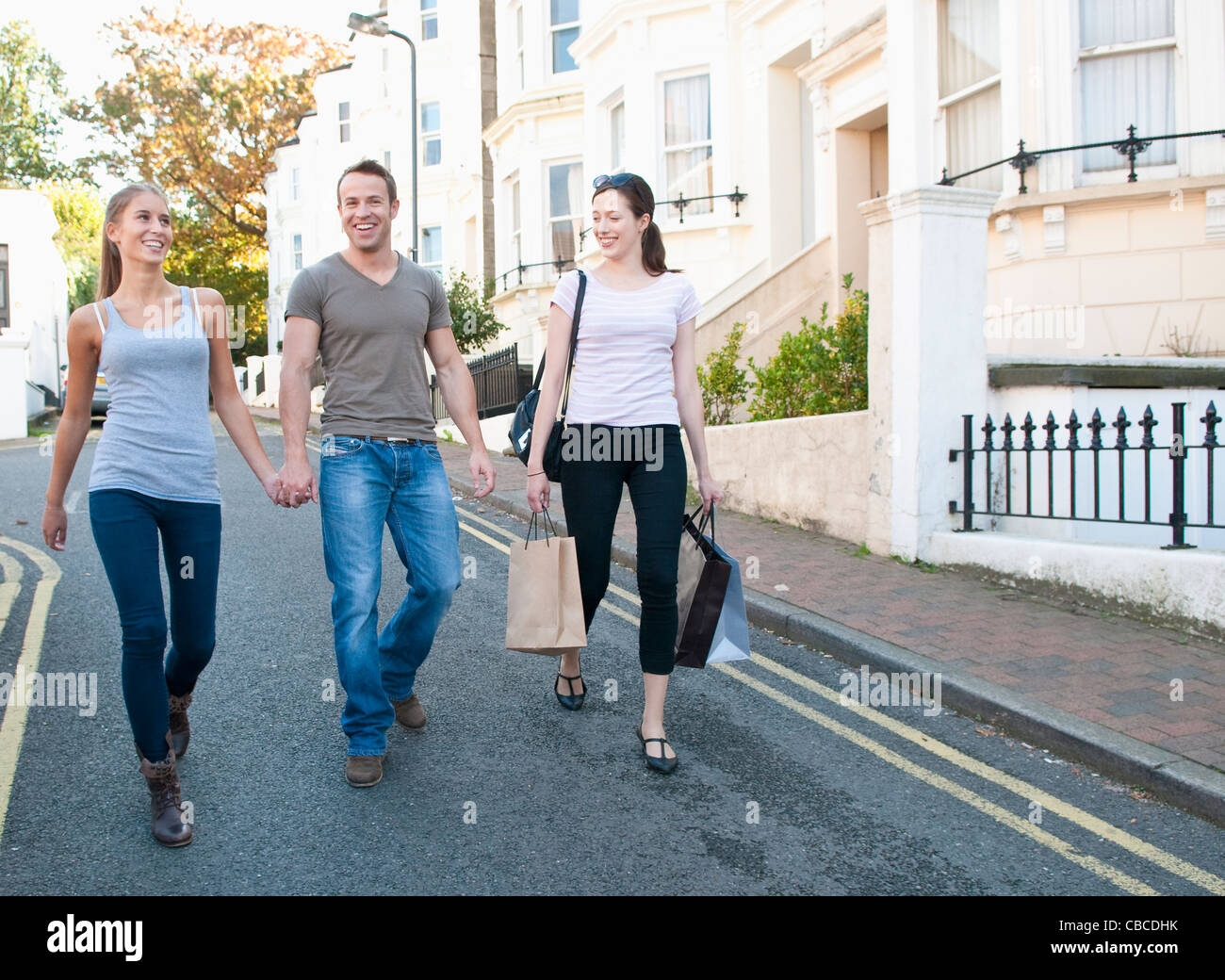 Friends walking on village street Stock Photo - Alamy