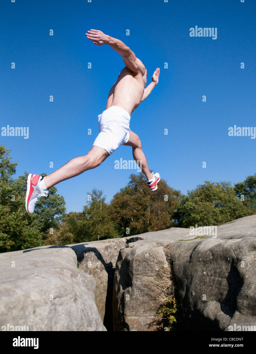 Rock climber jumping between rocks Stock Photo - Alamy