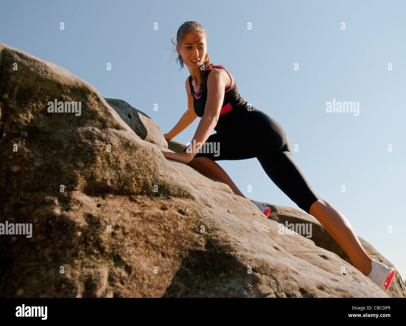 Rock climber scaling rock face Stock Photo - Alamy