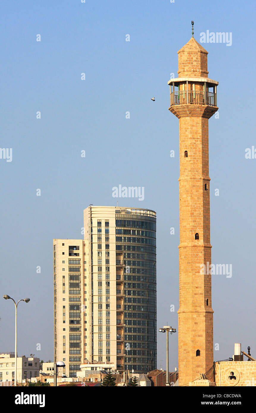 Vertical oriented image of old mosque and modern building in Tel Aviv ...