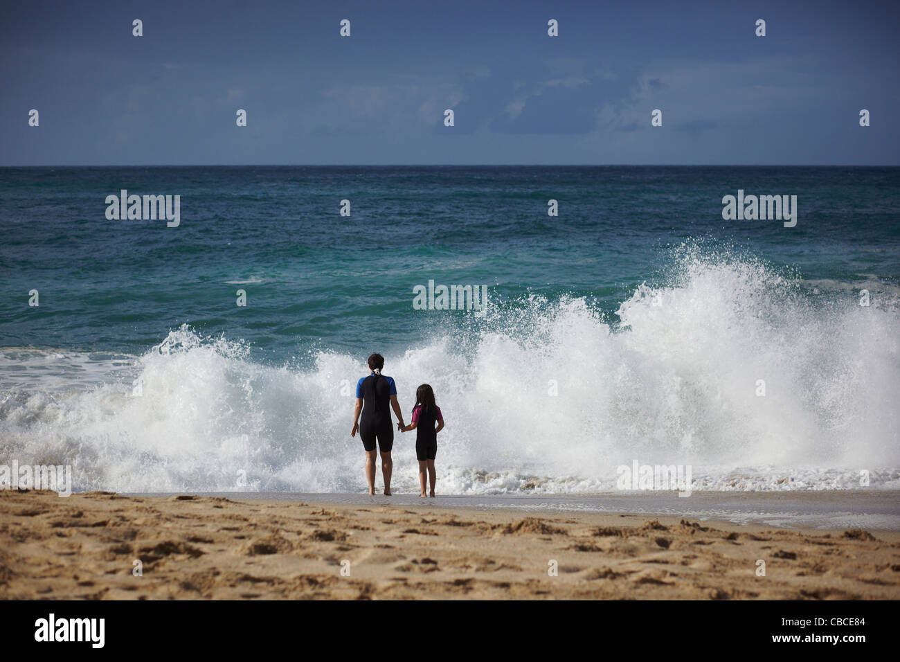 People looking at waves on a beach Stock Photo - Alamy