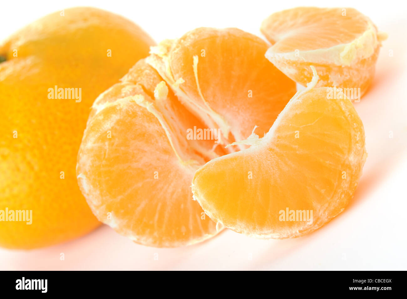 Segments and the whole tangerine. A detailed photo of fruit on a white ...