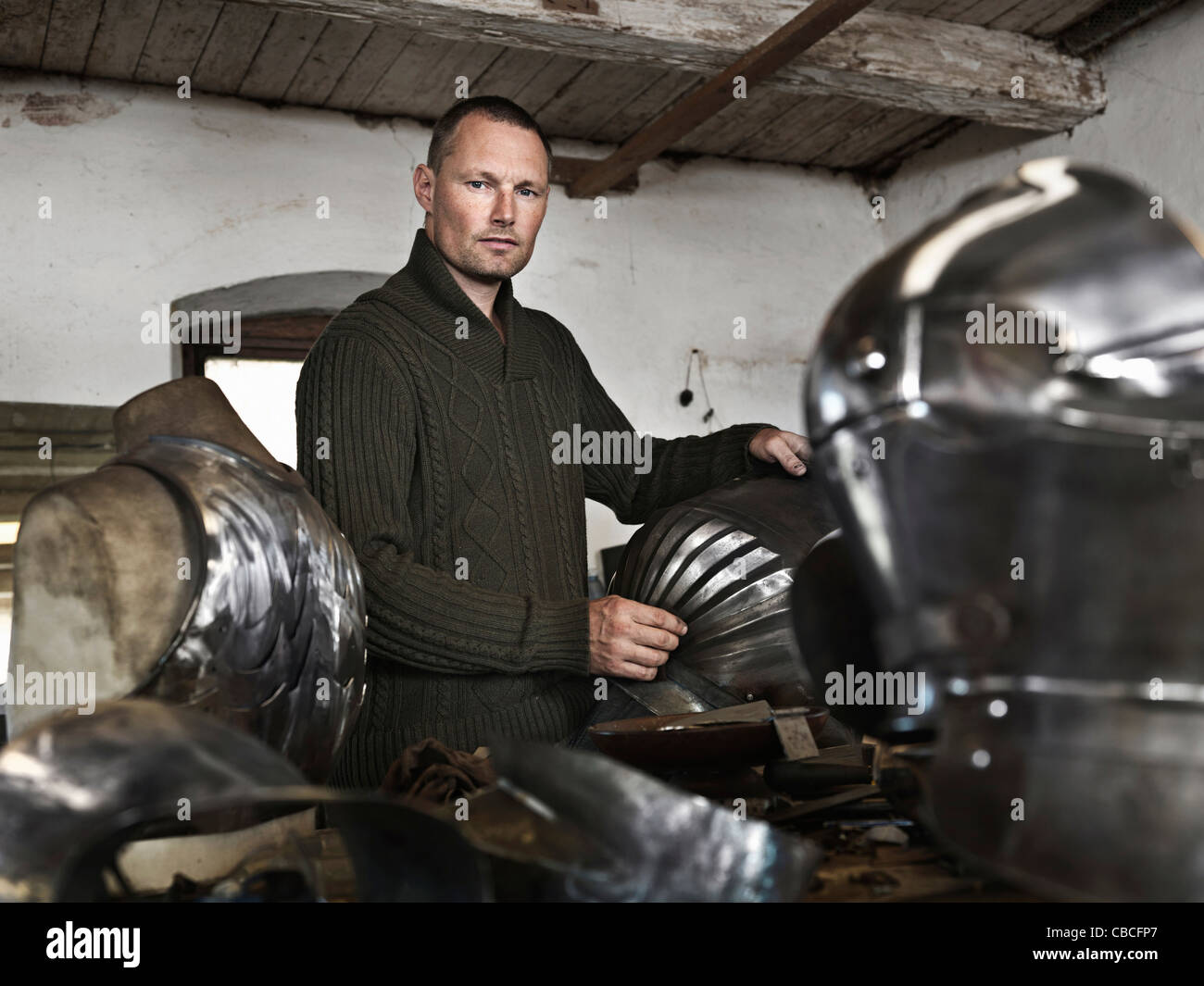 Blacksmith crafting armor in shop Stock Photo - Alamy