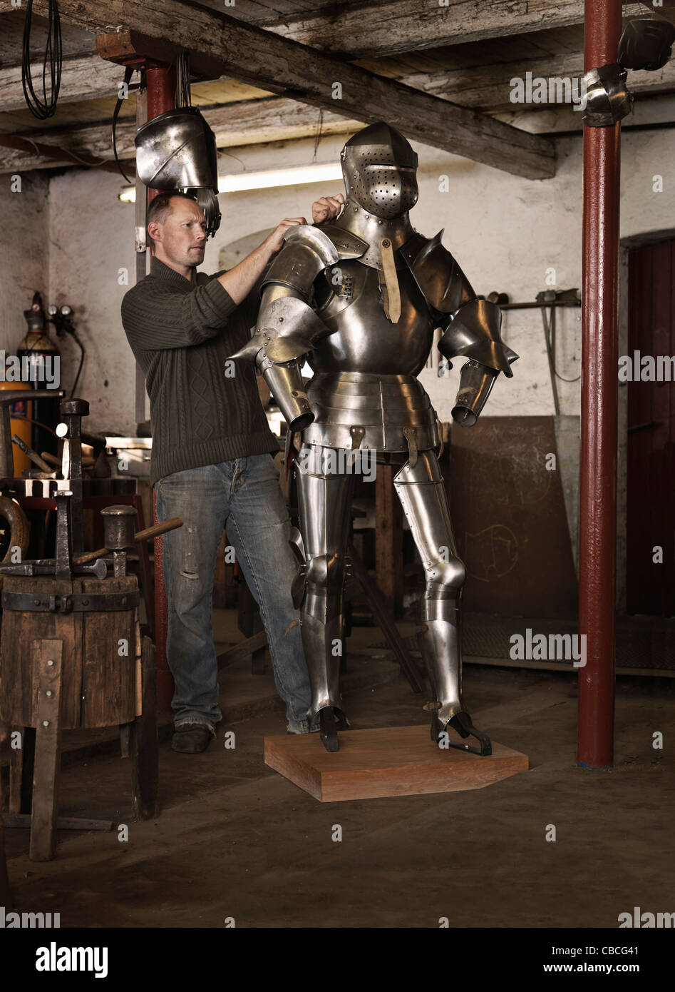 Blacksmith crafting armor in shop Stock Photo - Alamy