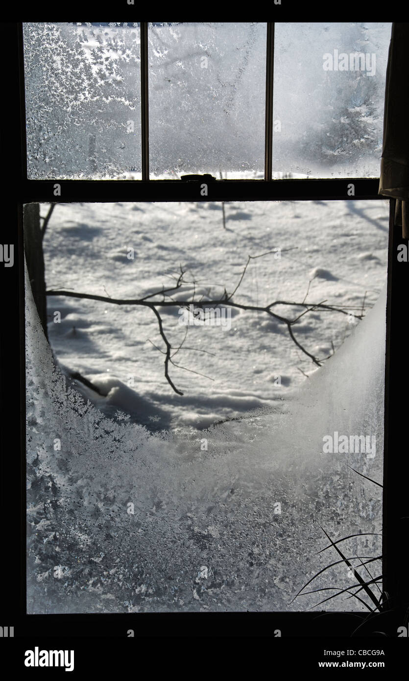 An icy window looking out on a snowy scene Stock Photo - Alamy