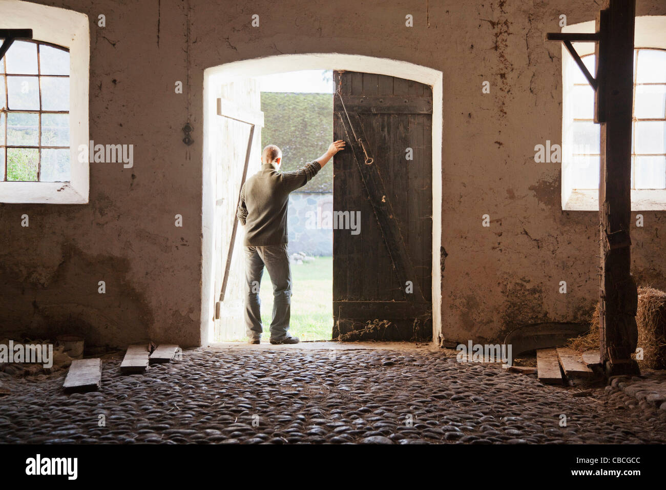Man standing at barn doors Stock Photo - Alamy
