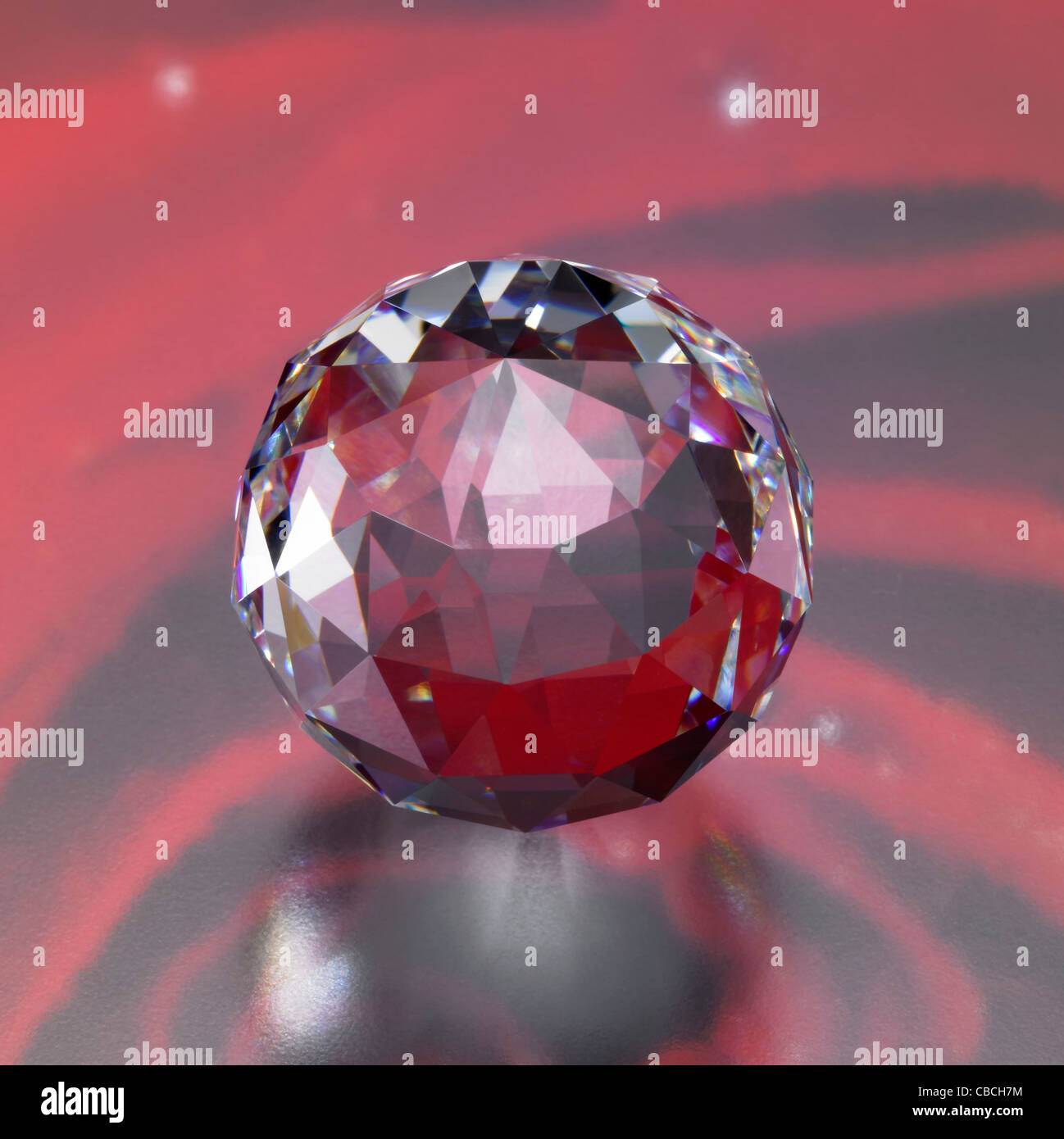 Studio photography of a diamond ball made of glass in red abstract back ...