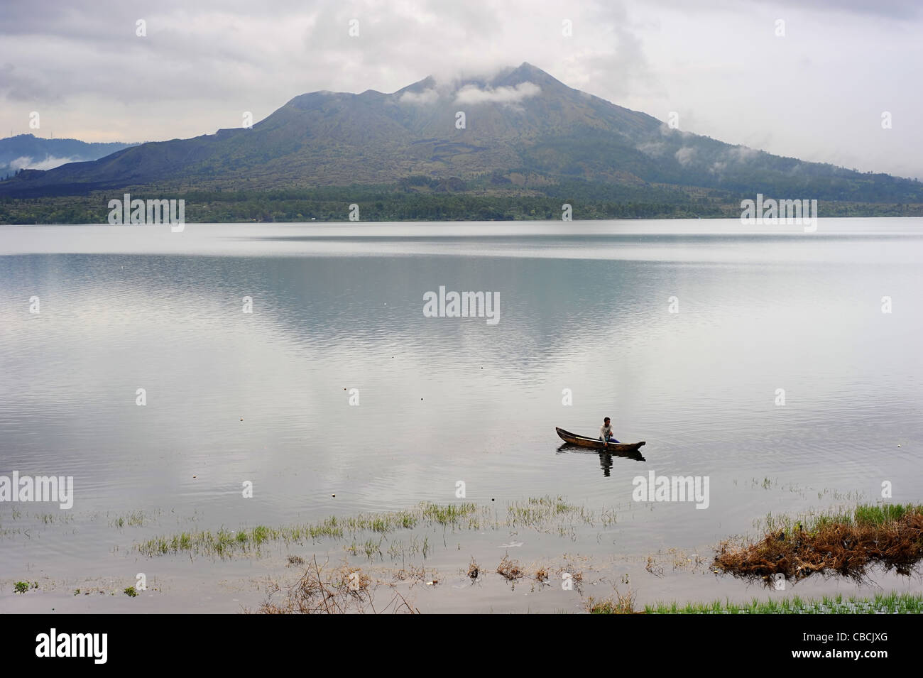 Man fishing in a caldera lake of Batur volcano. Batur is the most ...