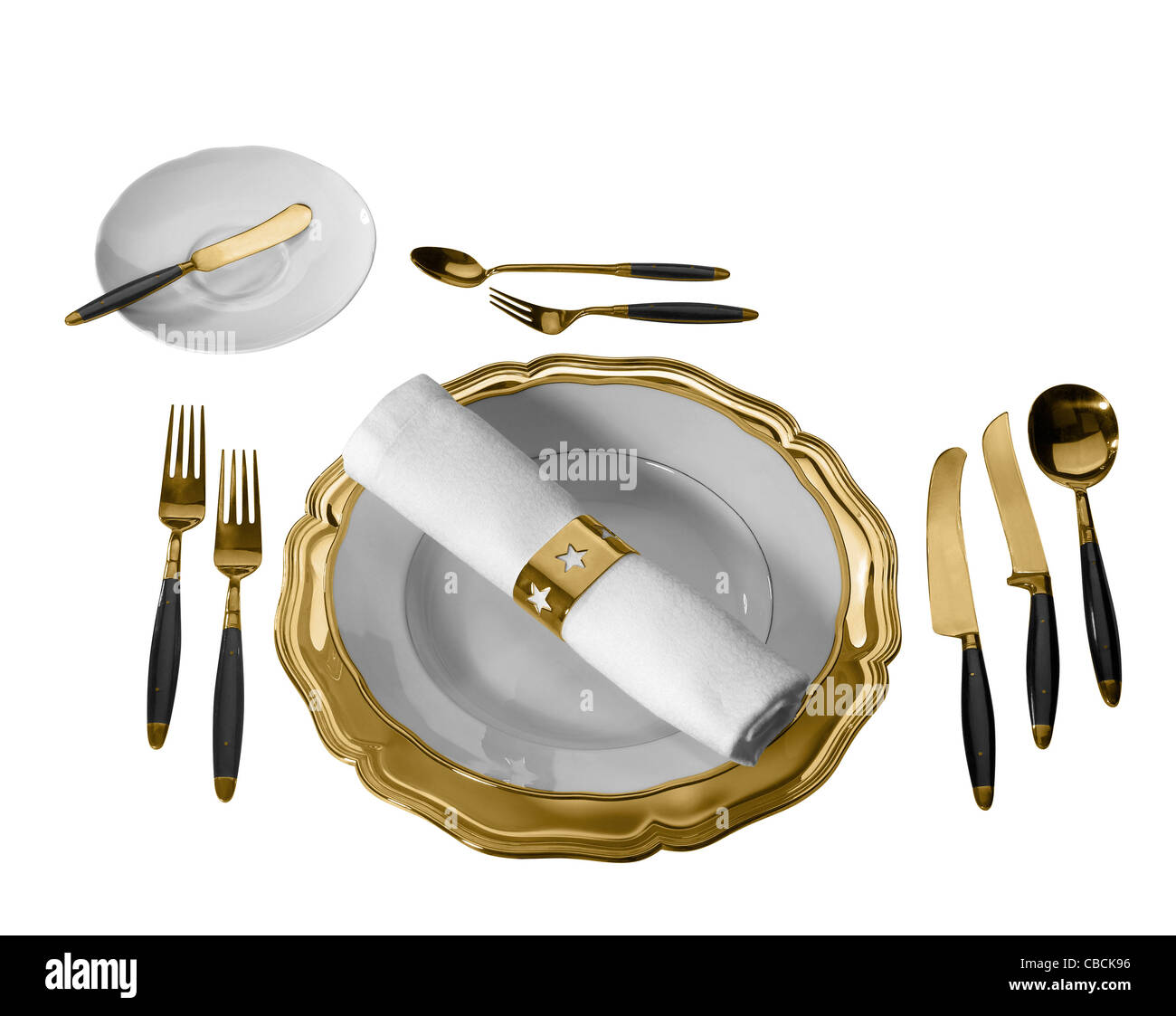 studio photography of a festive golden place setting in white back ...