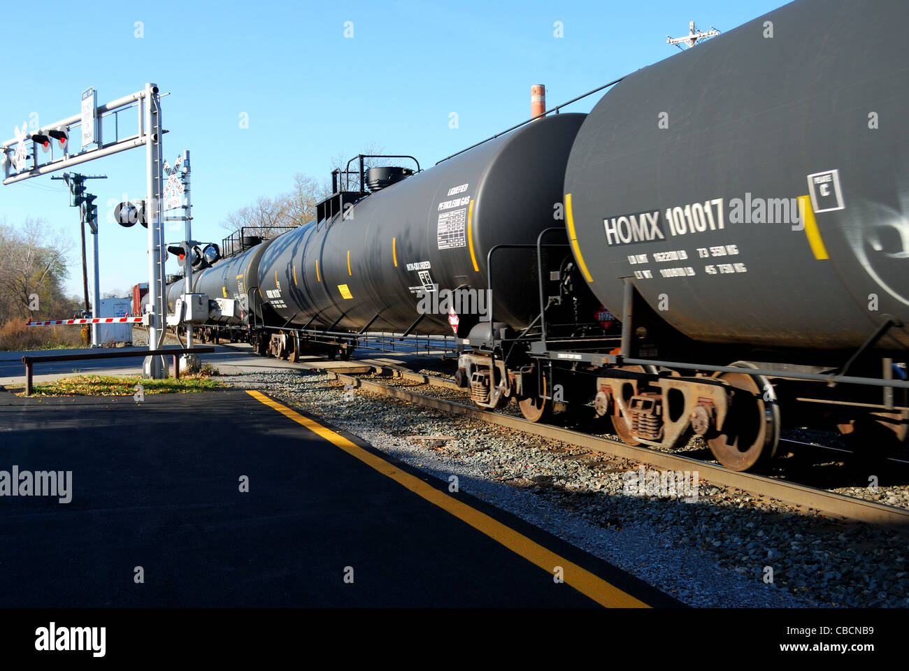 Freight train passes through road intersection Stock Photo - Alamy