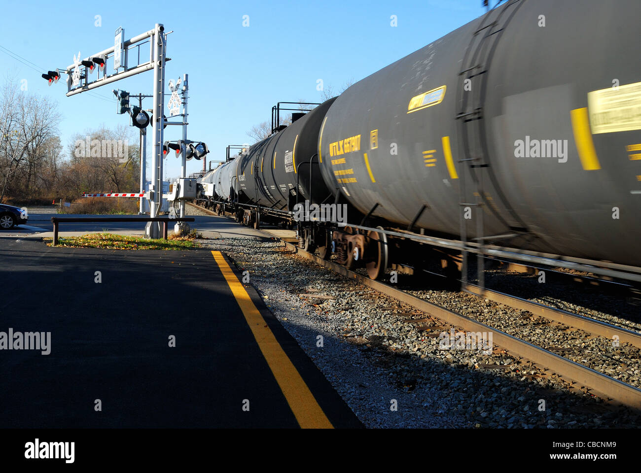 Freight train passes through road intersection Stock Photo - Alamy