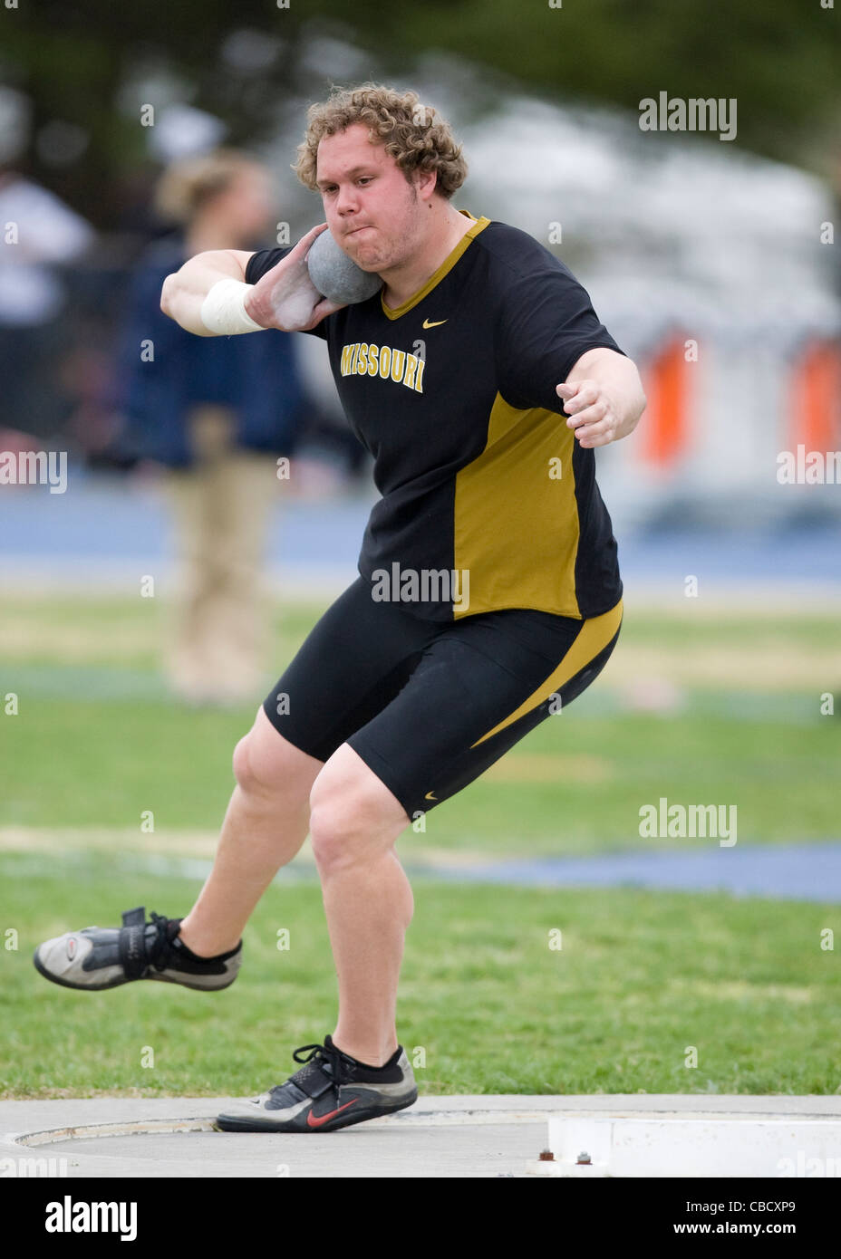 A male athlete throws a shot put during a track and field meet Stock ...