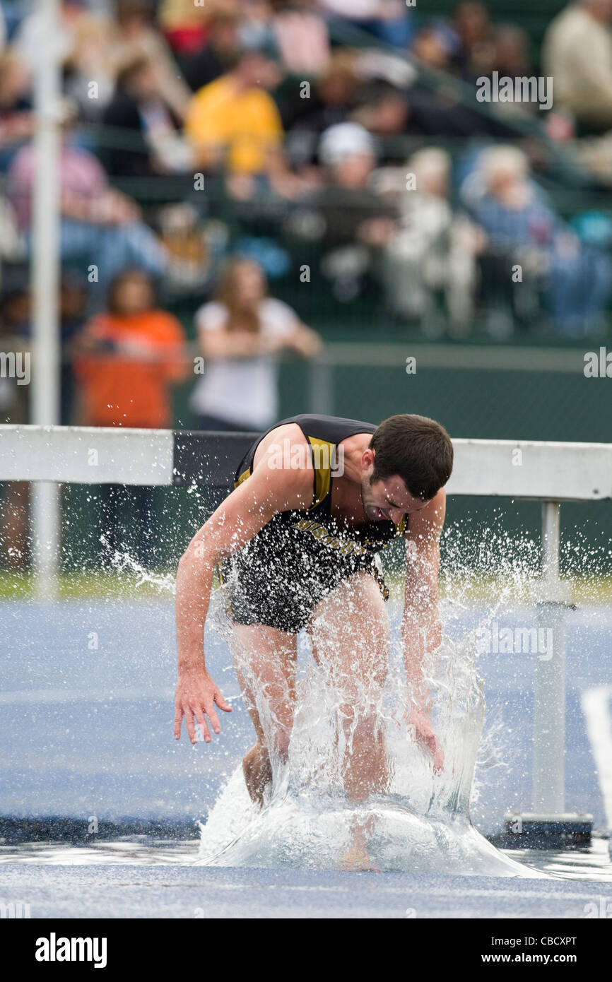 A male runner falls into the water hazard during a steeplechase race ...