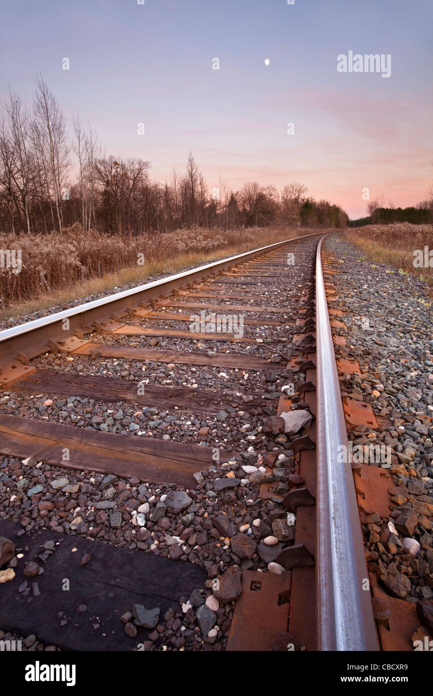 Train Tracks at sunset with the moon rising Stock Photo - Alamy