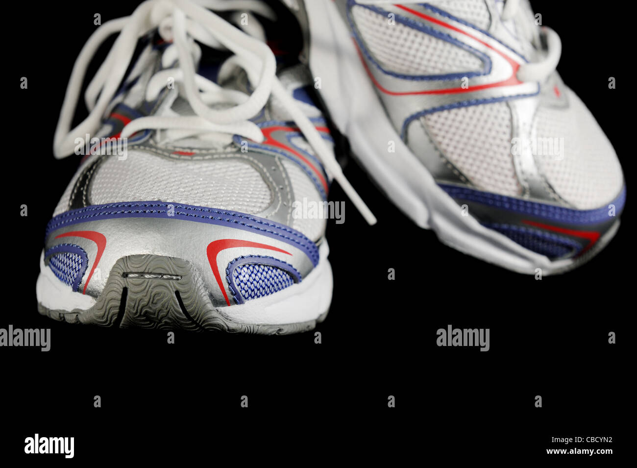 Pair of athletic shoes isolated on black background Stock Photo - Alamy