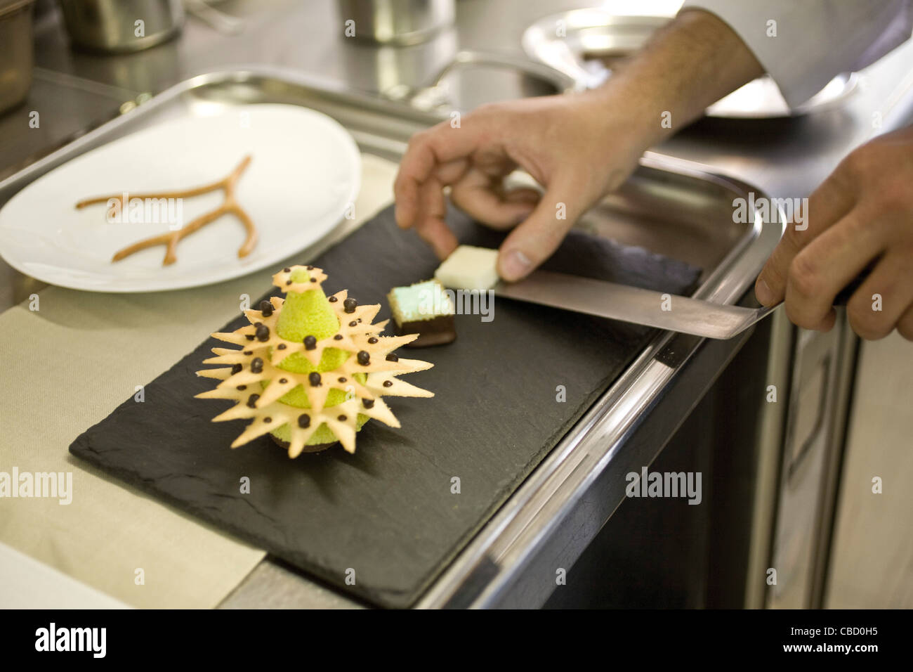 Chef assembling dessert shaped like Christmas tree Stock Photo - Alamy