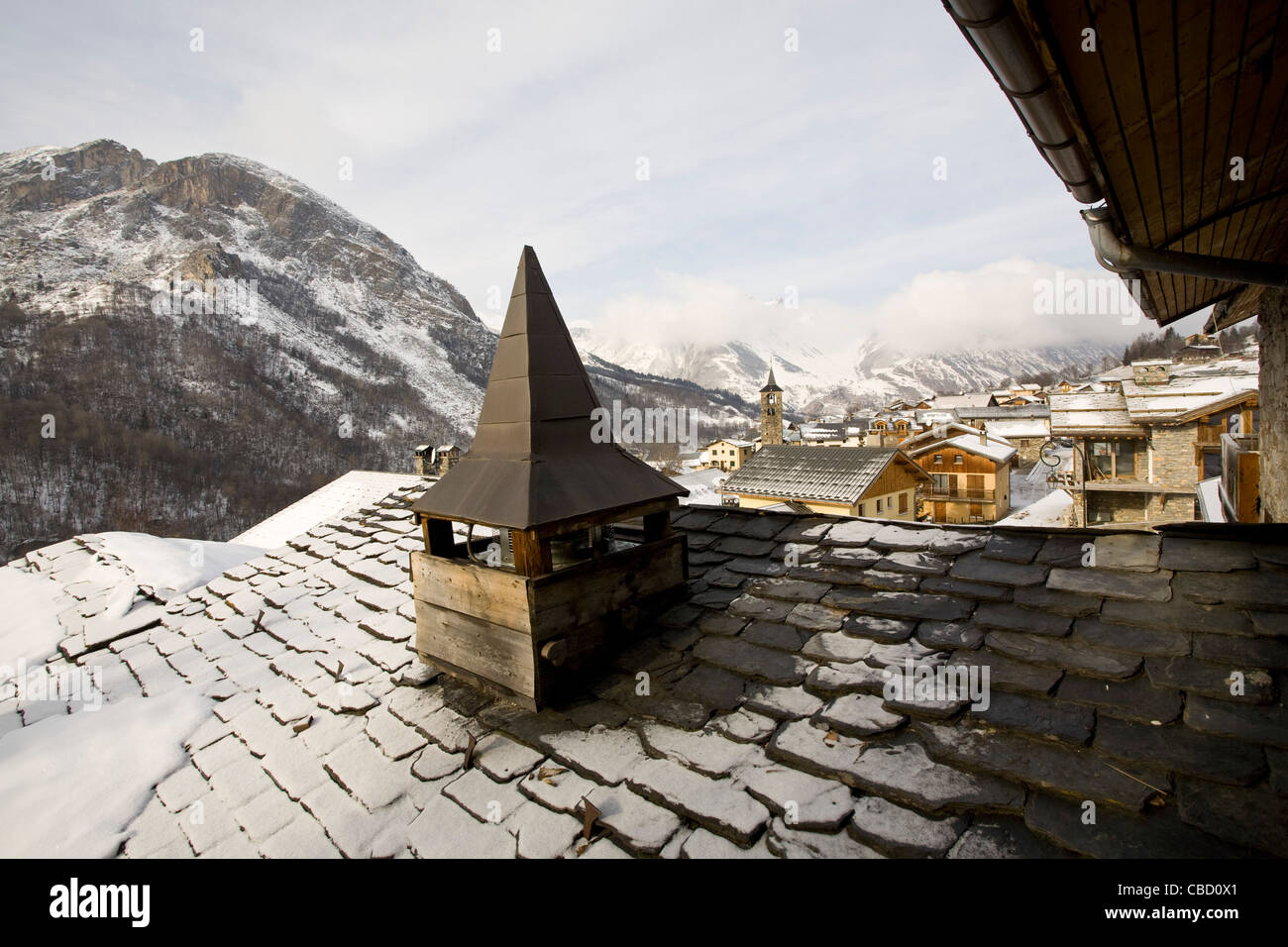 Snow-covered roof and chimney, cityscape in background Stock Photo - Alamy