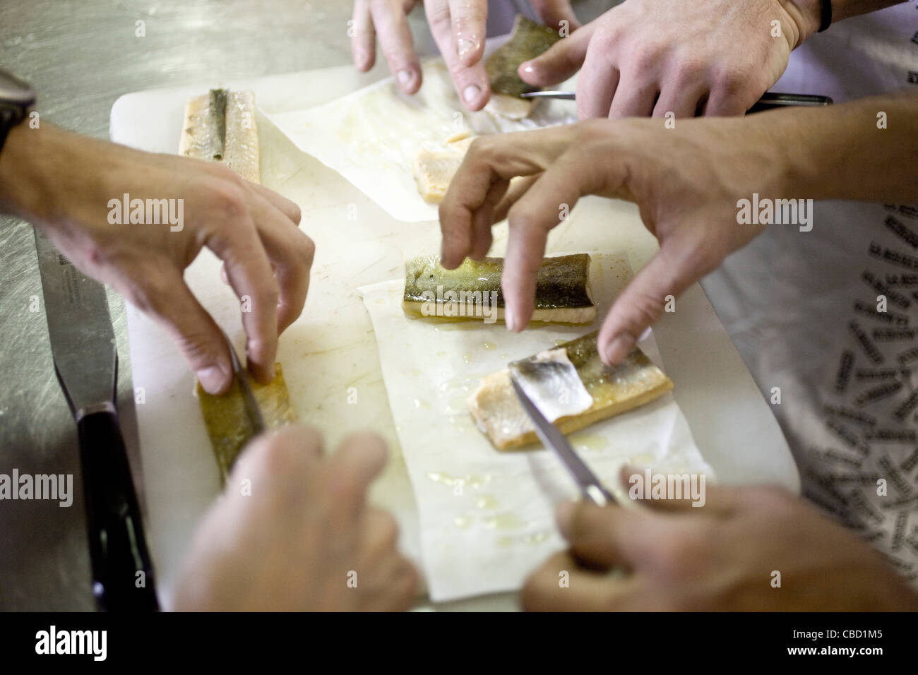 Chefs preparing fish, cropped Stock Photo - Alamy