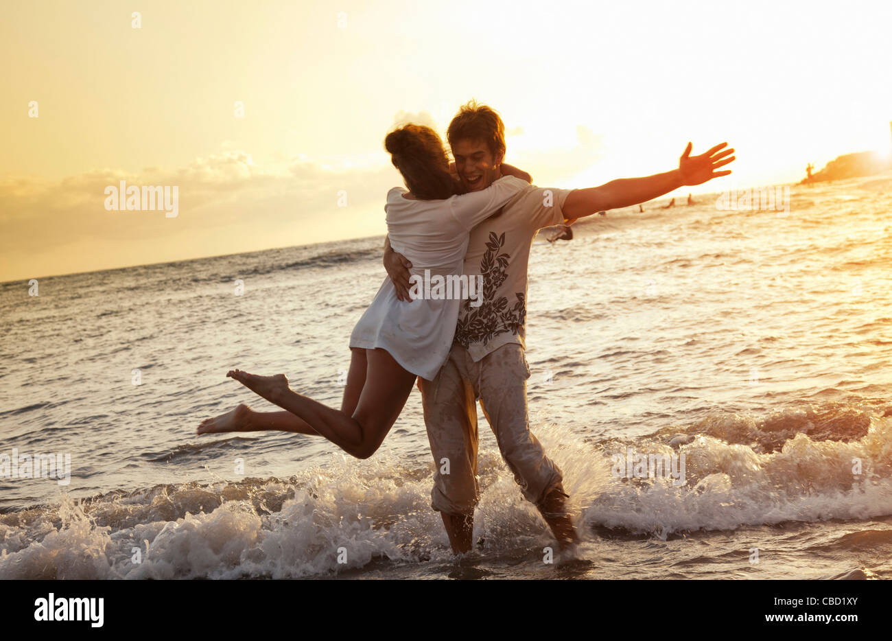Couple playing in waves at beach Stock Photo - Alamy