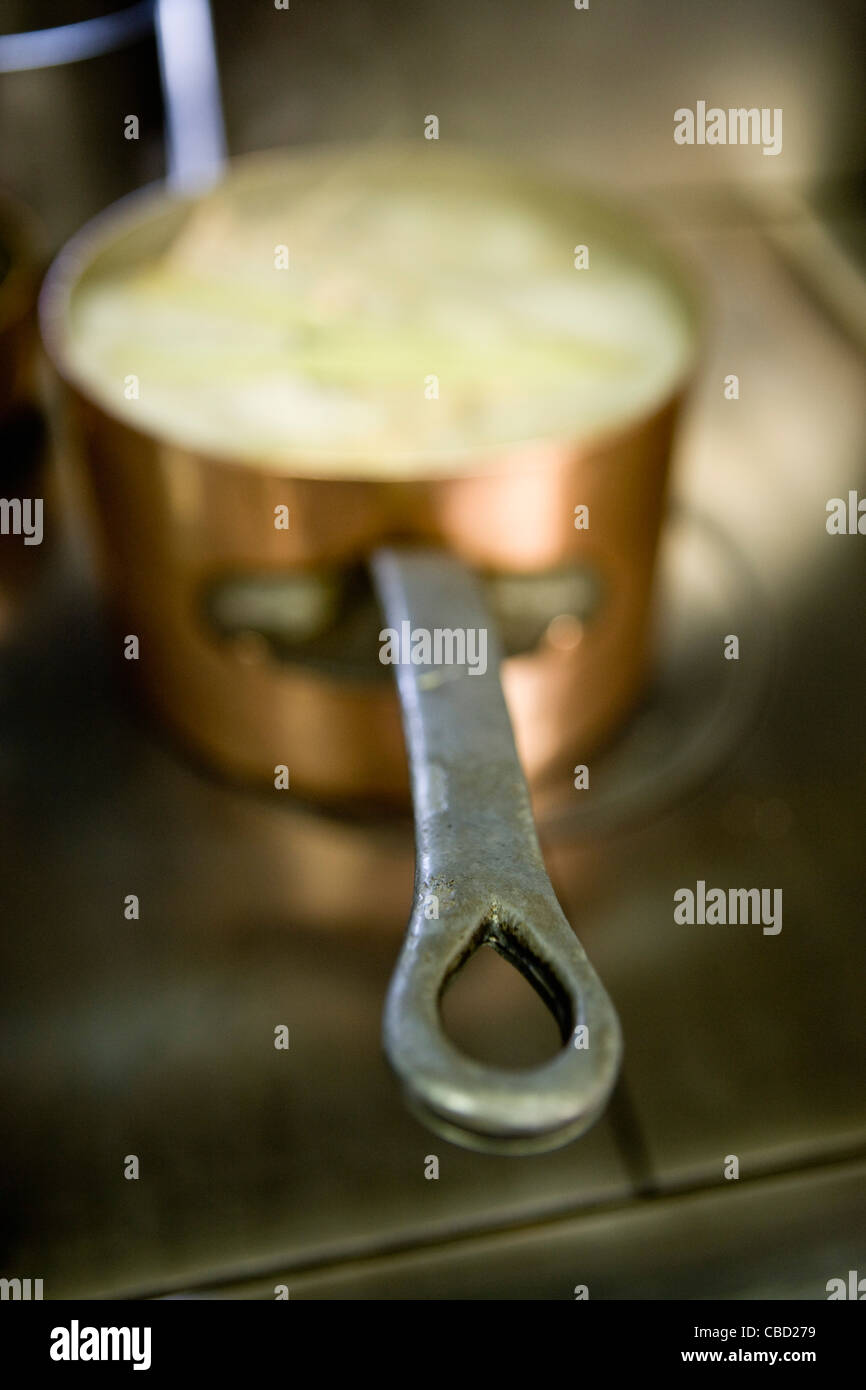 Pot of soup boiling on stove, focus on handle Stock Photo - Alamy
