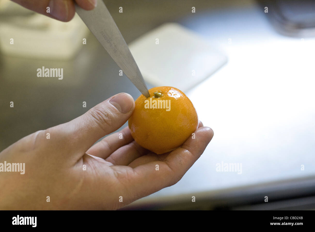 Cutting open mandarin orange Stock Photo - Alamy