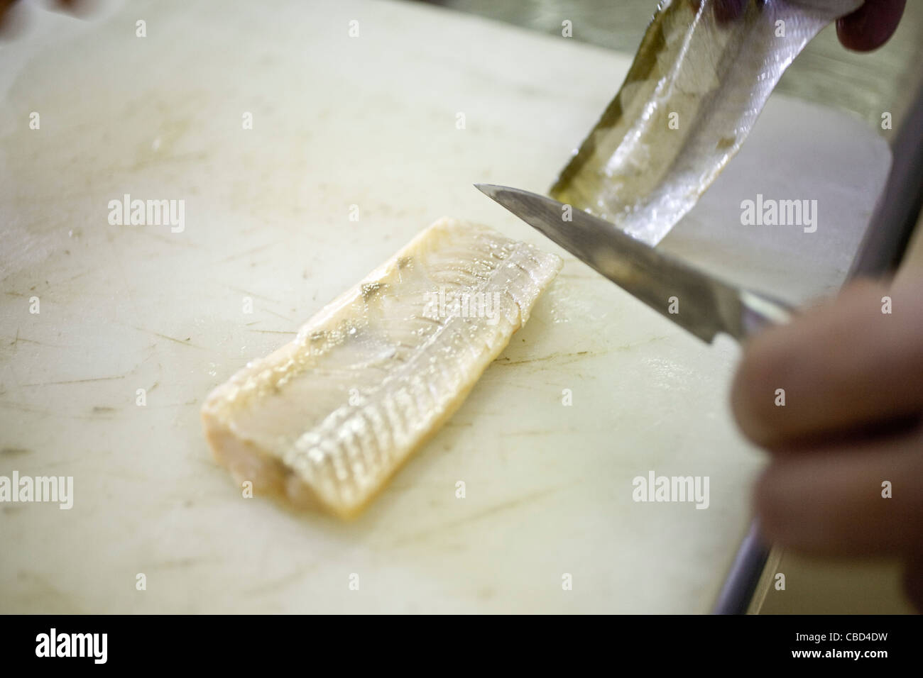Removing skin from fish Stock Photo - Alamy